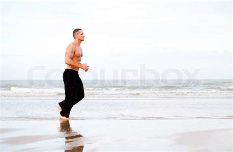 Babe Handsome Muscular Man Running On The Beach Stock Image Colourbox