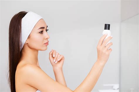 화장품 한 병을 들고 있는 젊은 아름다운 여성의 초상화 스킨 케어 컨셉 갈색 머리에 대한 스톡 사진 및 기타 이미지 갈색 머리 개념 건강 진단 Istock