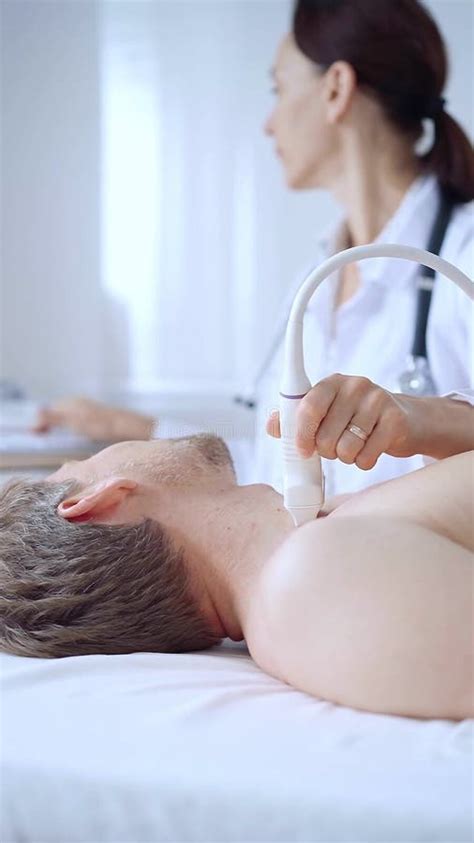 Doctor Woman Performing Neck Ultrasound Exam On Male Patient Medicine