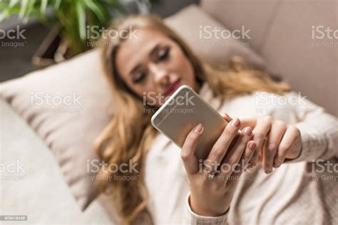 집에서 소파에 스마트폰 사용 하는 젊은 여자의 근접 촬영 무선 기술에 대한 스톡 사진 및 기타 이미지 무선 기술 백인종