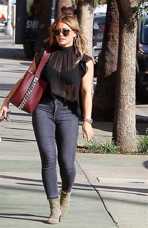 Hilary Duff Wearing A Sheer Black Mock Neck Top With Ruffled Sleeves Dark Gray Skinny Jeans