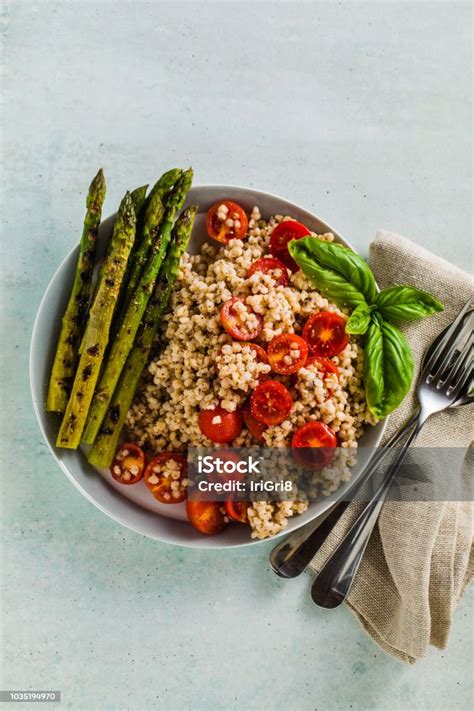 샐러드 글루텐 밀 구운 아스파라거스와 체리 토마토 Tahini 참 깨 파스타 소스와 라임 주스와 테이블에 접시에 체 강 질병을