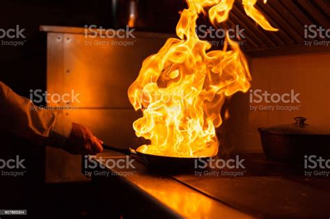 Flambe 어린 양 갈비 구이입니다 프라이팬에 화재와 요리 상업용 주방 요리에 전문 요리사입니다 야외 부엌에 홉에 불타는 냄비에 튀김 음식 남자 슬로우 모션 갈빗살 구이에