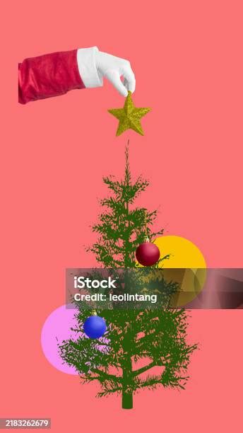 산타 클로스 손은 컬러 배경에 크리스마스 공을 크리스마스 트리 위에 노란색 별을 넣었습니다 12월에 대한 스톡 사진 및 기타 이미지 Istock
