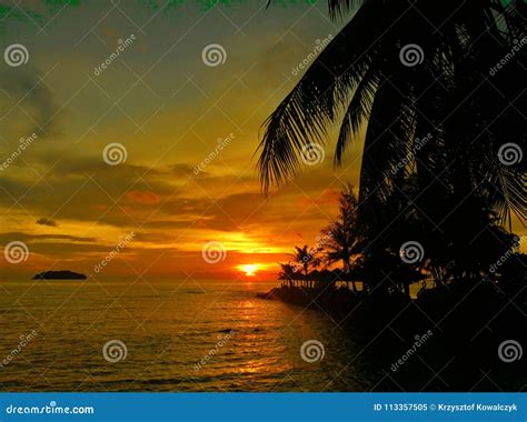 Fiery Glow Sunset Over A Beautiful Tropical Beach And Ocean Water