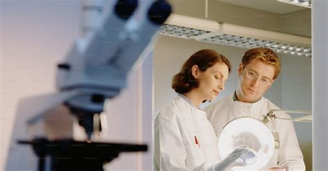 하얀 실험복을 입은 남자와 여자가 하얀 물체를 보고 있다 사진 Unsplash의 의료 종사자 이미지