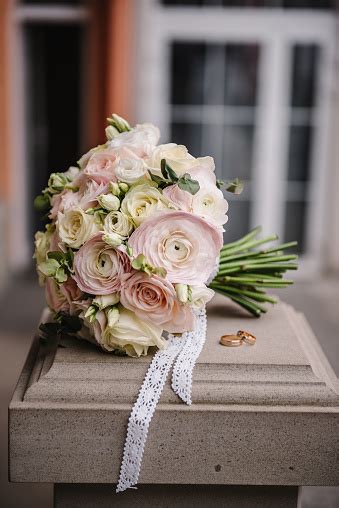 꽃다발 흰색과 분홍색 꽃 장미 결혼 반지 신부와 신랑이 있는 녹지 두 개의 아름다운 황금 결혼 반지 남성 여성용 반지 장식 약혼 세부 사항 웨딩 및 액세서리 0명에 대한