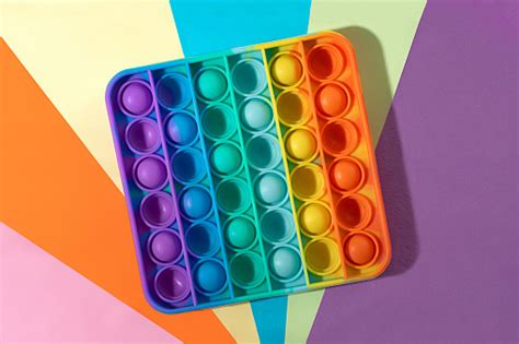 감각 장난감의 상단 보기는 여러 가지 빛깔의 배경에 팝 무지개 색 복사 공간이 있는 배너만큼 좋습니다 어린이와 성인을위한 안티