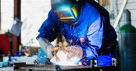 작업장에서 용접 장치와 금속을 접착하는 용접기 많은 불꽃을 볼 수 있으며 용접 고글을 착용합니다 사진 Unsplash의 산업 이미지