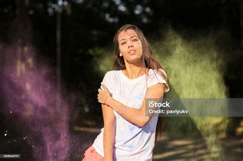 흰색 셔츠를 입고 녹색과 보라색 홀리 페인트로 연주 하는 웅장한 무두질 아시아 모델 20 24세에 대한 스톡 사진 및 기타