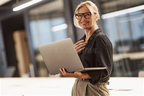 A Professional Woman Working On A Laptop In A Contemporary And Modern Office Environment Stock