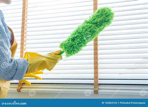Young Female Spring Cleaning House Interior Holding A Duster For Wiping