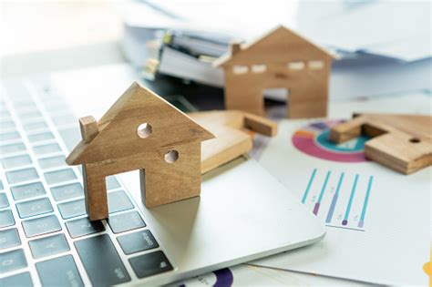 대출 부동산에 대한 주택 모델은 가족 또는 부동산 모기지 투자 개념에 대한 새로운 구입 차트 보고서 문서와 노트북 컴퓨터에 나무 집 모델 기관 온라인 자산 관리 구매에 대한