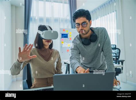 Asian Software Developer Wearing A Virtual Reality Headset Works On A Vr Project With A