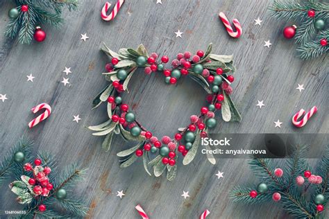 장식 심장 모양의 겨우살이 화환 천연 전나무 나뭇 가지 붉은 흰색 크리스마스 스트라이프 사탕 지팡이와 붉은 열매로 장식 된 나무 크리스마스 배경 0명에 대한 스톡 사진 및