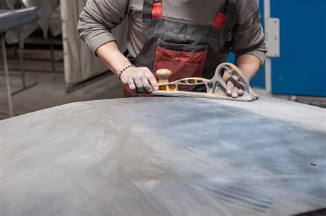 차량 작업장에서 사고로 신체 부위에 파손 후 프라이머를 적용하기 전에 서비스 기술자가 에머리 송신기를 사용하여 자동차 부품을 페인팅하는 준비 차에 대한 스톡 사진 및 기타