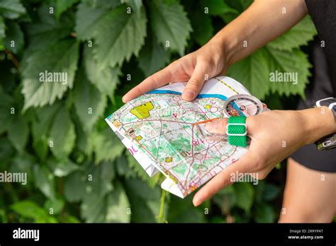 Woman Holding A Map And The Compass During Orienteering Competitions Athlete Uses Navigation