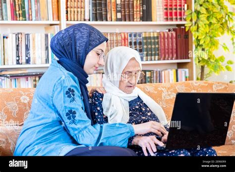 Happy Muslim Grandmother And Her Granddaughter Sitting Together On