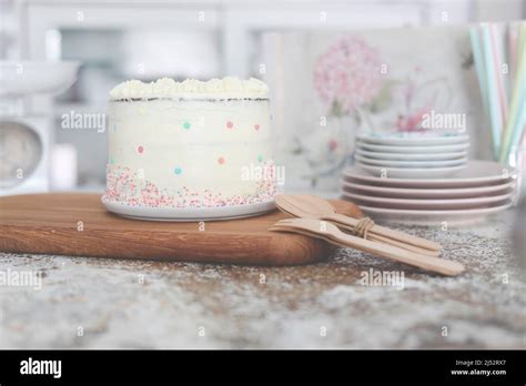 Layer Cake With Buttercream Frosting And Sprinkles On A Table With A