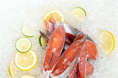 신선한 바다 바다 붉은 물고기는 조각으로 잘라 머리없이 얼음에 거짓말 체리 레몬과 라임의 조각은 둥근 잘라 주위에 거짓말 바질 빛 측면에서 상단보기 강에 대한 스톡 사진 및