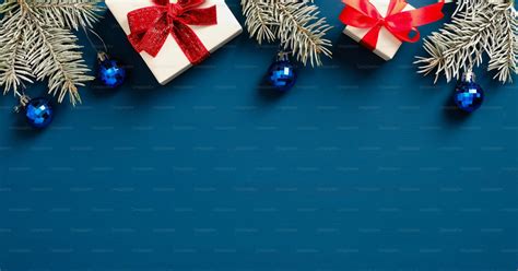 메리 크리스마스와 새해 복 많이 받으세요 인사말 카드 디자인 흰색 선물 상자로 만든 크리스마스 프레임 테두리는 빨간 리본 활 소나무 나뭇 가지 진한 파란색 배경에 공