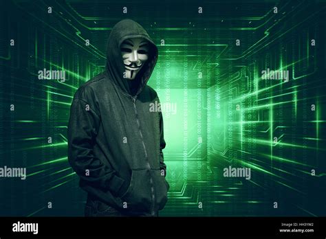Hooded With Anonymous Mask Standing With Binary Code On Background