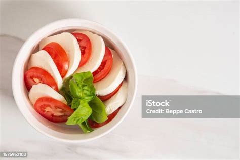 대리석 테이블과 배경에 흰색 접시 그릇에 카프리스 샐러드에 대한 붉은 토마토 녹색 바질과 흰색 버팔로 모짜렐라의 Fatlay 0명에 대한 스톡 사진 및 기타 이미지 Istock