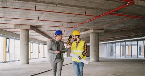 건설 노동자와 건축가는 건설 과정에서 건물을 걷고 프로젝트에 대해 논의합니다 사진 Unsplash의 산업 이미지
