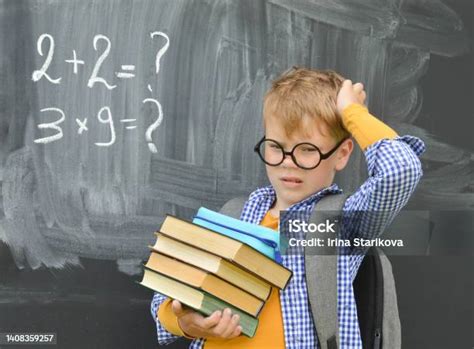 학교로 돌아 가기 그의 머리를 생각하고 긁는 안경으로 작은 백인 소년을 화나게합니다 책과 가방을 들고 초등학교 출신의 아이 남학생에 대한 스톡 사진 및 기타 이미지 Istock