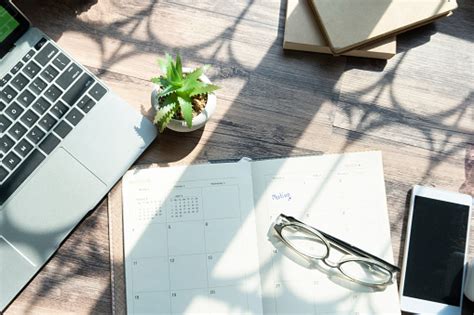 홈 컨셉에서 온라인으로 작업 노트북 스마트폰 안경 선인장 일기를 사무실 책상에 놓습니다 플래너가 일일 시간표 의제 와 일자리 약속을 계획할 수 있도록 캘린더 및 예약합니다