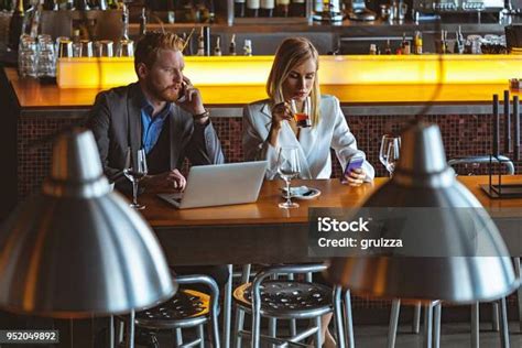 남자와 여 자가 그들의 스마트폰을 사용 하 여 고급 레스토랑에서 점심 시간 동안 테이블에 대 한 함께 앉아있는 동안 2명에 대한 스톡 사진 및 기타 이미지 Istock
