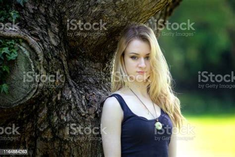 캐주얼 편안한 머리와 어깨 초상화 의 예쁜 금발 대학 학생 미소와 나무 아래에서 카메라를 보고 고요한 장면에 대한 스톡 사진 및 기타 이미지 Istock