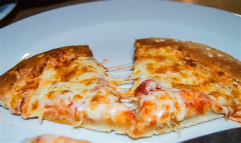 선택적 초점의 클로즈업 나무 테이블에 카페에서 흰색 접시에 스트레칭 치즈와 뜨거운 피자의 두 조각 0명에 대한 스톡 사진 및