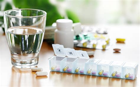 식탁에 물 한 잔이 있는 비타민과 의약품의 일일 알약 상자 주최자 0명에 대한 스톡 사진 및 기타 이미지 0명 건강관리와 의술 건강한 생활방식 Istock