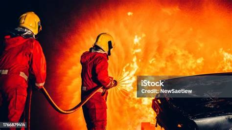 물과 소화기로 불길과 싸우는 용감한 소방관들 팀워크와 용기로 화재를 진압하는 소방관 강도 높은 소방 훈련 2명에 대한 스톡 사진 및 기타 이미지 Istock