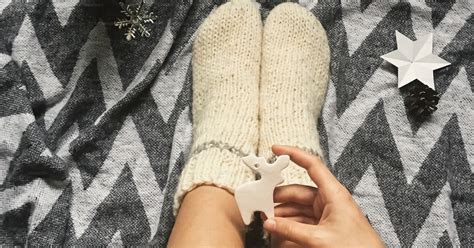 크리스마스 모직 양말과 세련된 순록 장난감을 손에 들고 소녀 다리에서 휴일 장식품을 가지고 노는 귀여운 고양이 평면도 분위기 있는 아늑한 이미지 따뜻한 겨울 분위기