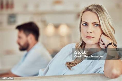 아내는 남편과 싸우고 침묵의 치료를하면서 술렁입니다 백인 여성은 소파에 앉아서 집에서 남자 친구와 논쟁을 벌인 후 생각합니다 서로를 무시하는 불행한 커플 슬픔에 대한 스톡