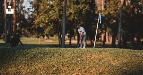 흰색 셔츠와 검은 바지를 입은 남자가 낮에 골프를 친다 사진 Unsplash의 무료 골프 이미지