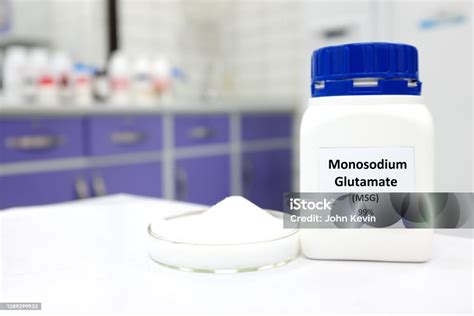 백색 고체 분말 물질을 가진 페트리 접시 옆에 순수한 단나트륨 글루타민트 또는 Msg 식품 첨가제 의 병의 선택적 초점 복사