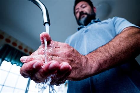 Premium Photo Low Angle View Of Man Washing Hands At Home