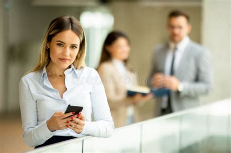 Young Business Woman With Mobile Phone In The Office Hallway Stock