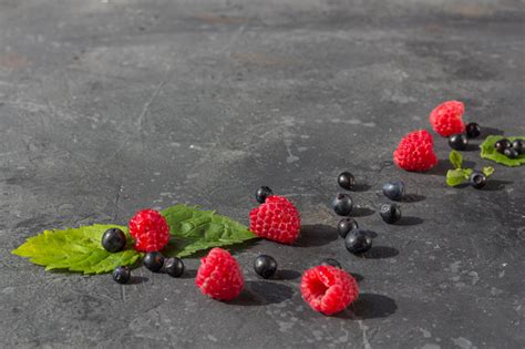 어두운 배경에 민트 잎신선한 육즙이 많은 라즈베리와 블루베리 검은 색에 여름 열매 건강 채식주의 자 식사 다이어트 평평한 평지 텍스트 공간을 복사합니다 0명에 대한 스톡