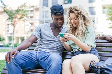 사랑 하는 부부 이야기 여름 동안 공원에서 벤치에 스마트 휴대 전화를 사용 하 여 2명에 대한 스톡 사진 및 기타 이미지 2명 공원 공원 벤치 Istock