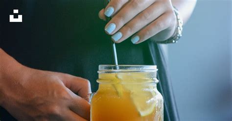 음료와 빨대가 있는 손잡이가 있는 유리 메이슨 항아리를 들고 있는 사람 사진 Unsplash의 무료 음식 이미지