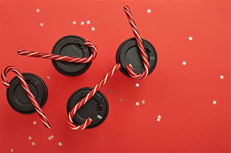 빨간 배경에 사탕수수와 종이 커피 컵 크리스마스 사탕 지팡이와 스타 색종이와 크리스마스 배경 상단보기 플랫 레이 모형 텍스트의 공간을 복사합니다 0명에 대한 스톡 사진 및