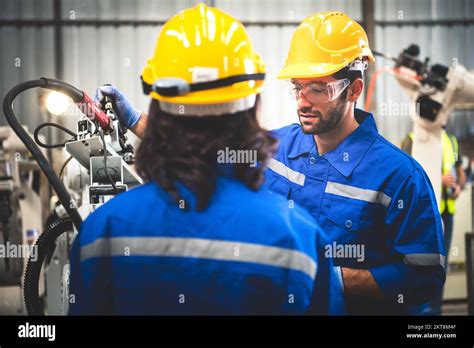 Two Engineers Mechanic Using Computer Controller Robotic Arm For