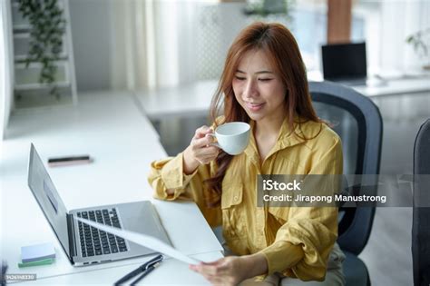 낮 시간 커피 브레이크 동안 책상에서 웃고있는 행복한 아시아 여성의 초상화 개념에 대한 스톡 사진 및 기타 이미지 개념