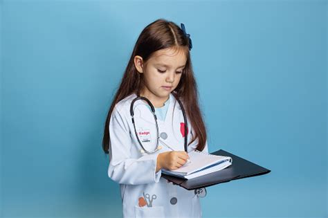 유치원 아름다운 소녀 블루 스튜디오 배경에 고립 된 포즈 흰색 의학 코트를 입고 의사의 이미지에 아이 6 7 살에 대한 스톡 사진 및 기타 이미지 Istock