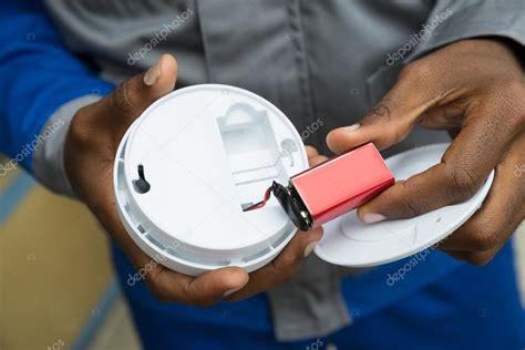 Electrician Removing Battery From Smoke Detector Stock Photo AndreyPopov 119314840