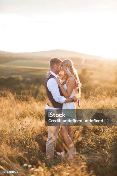산의 배경에 포즈 세련된 보헤미안 캐주얼 옷을 입고 남자와 여자 일몰 필드 세련 된 힙스터 커플 포옹 보보스에 대한 스톡 사진 및 기타 이미지 Istock